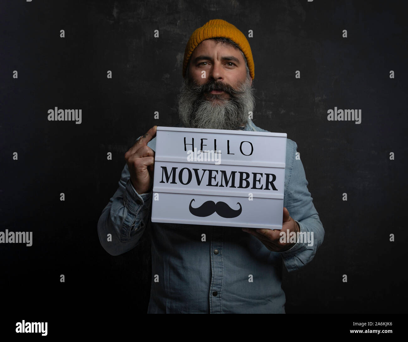 Movember concept. Portrait of man with beard and mustache holding a ...