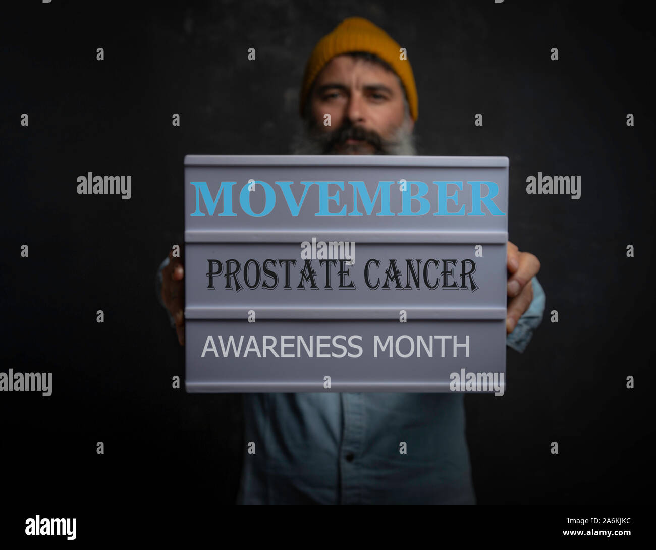 Movember concept. Portrait of unfocused bearded man holding a sign with ...