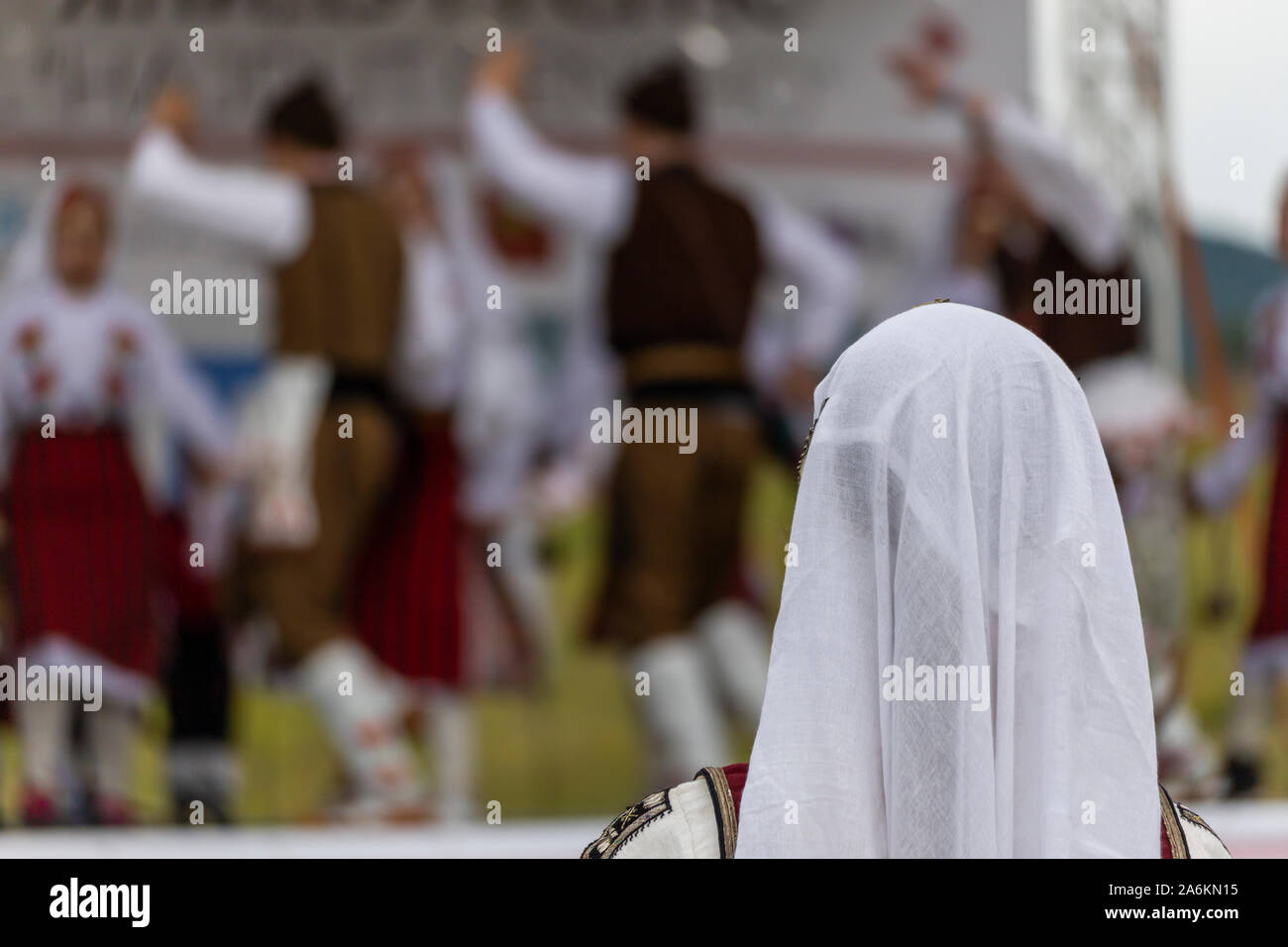 Back view of a woman watching performance of bulgarian traditional ...