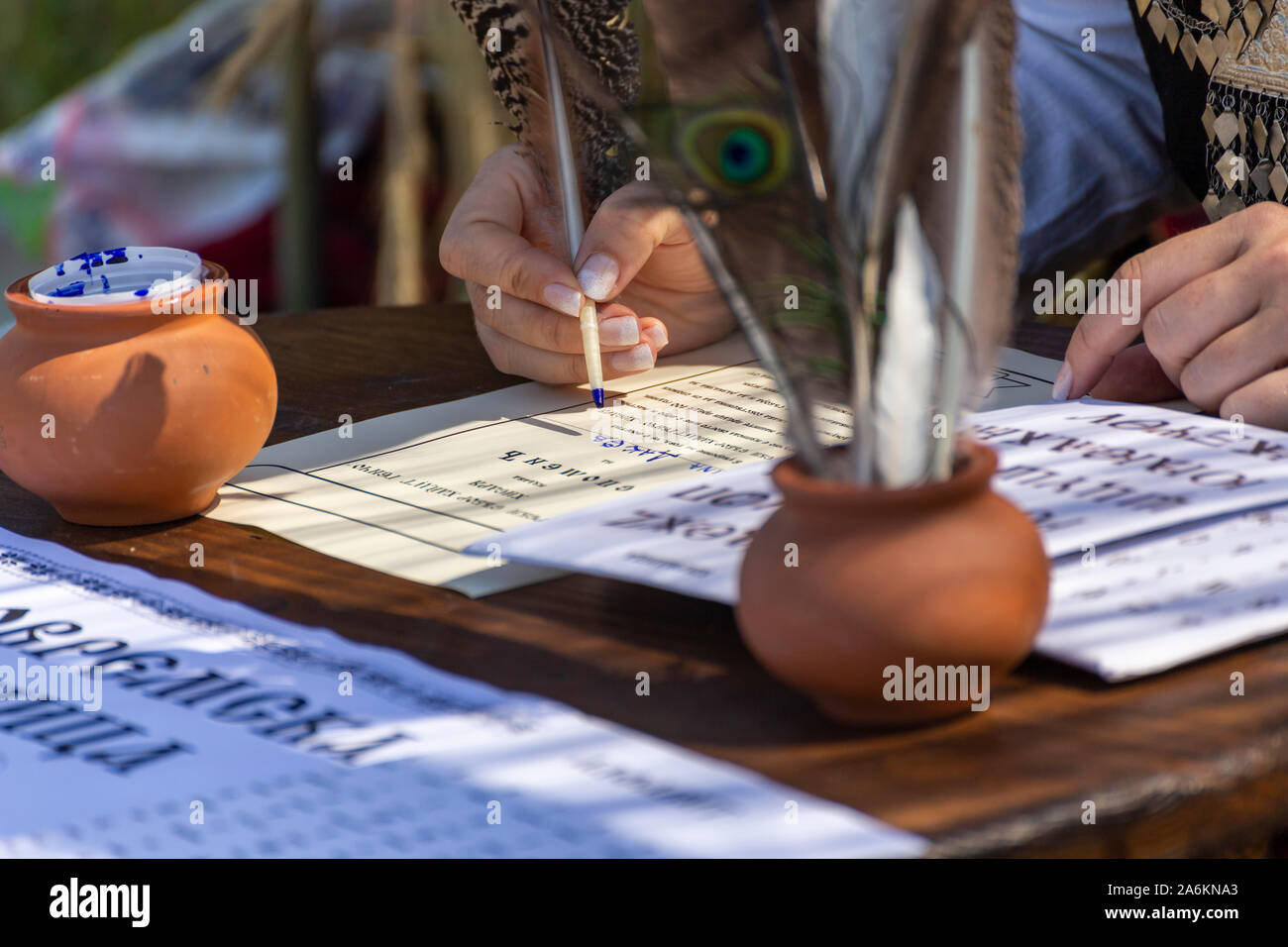 Woman writing a letter with a feather in ourdoors setting. Ancient ...