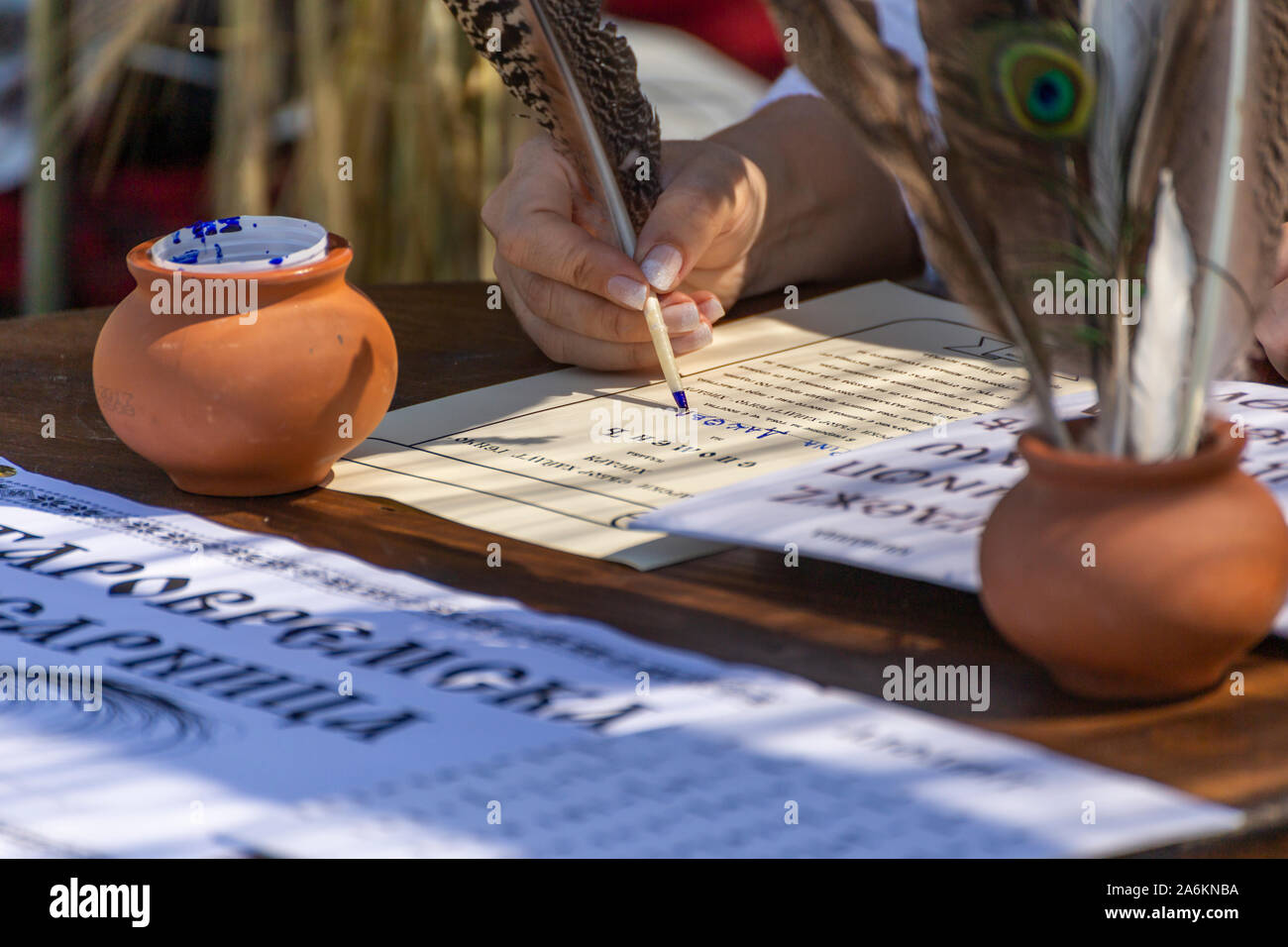 Woman writing a letter with a feather in ourdoors setting. Ancient ...
