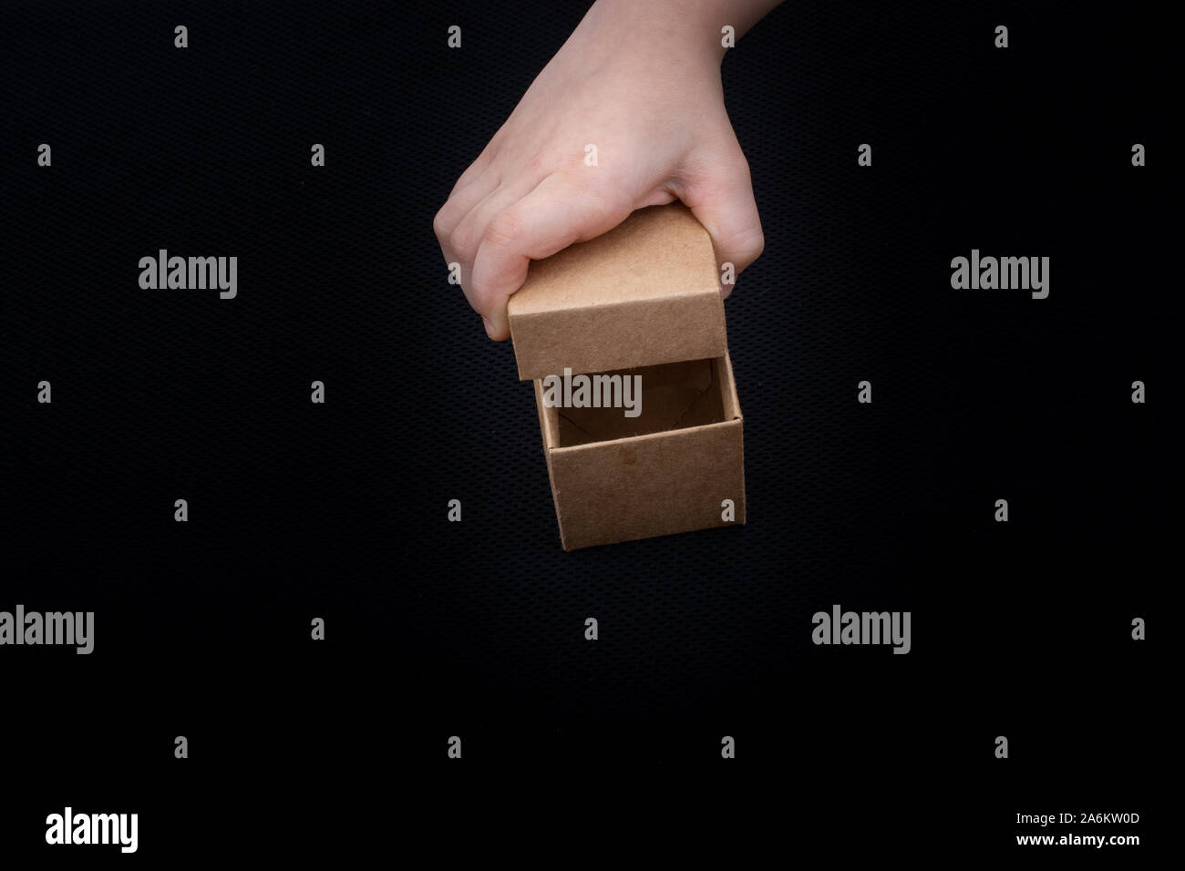 Hand opening a brown cardboard box on black backgrounds Stock Photo - Alamy
