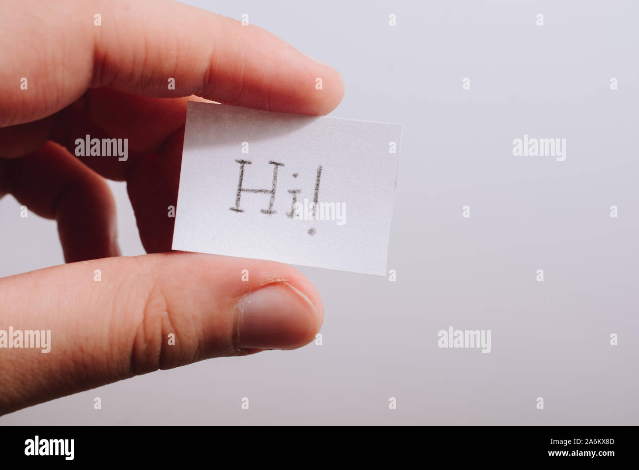 Hand holding notepaper with HI wording on white background Stock Photo ...