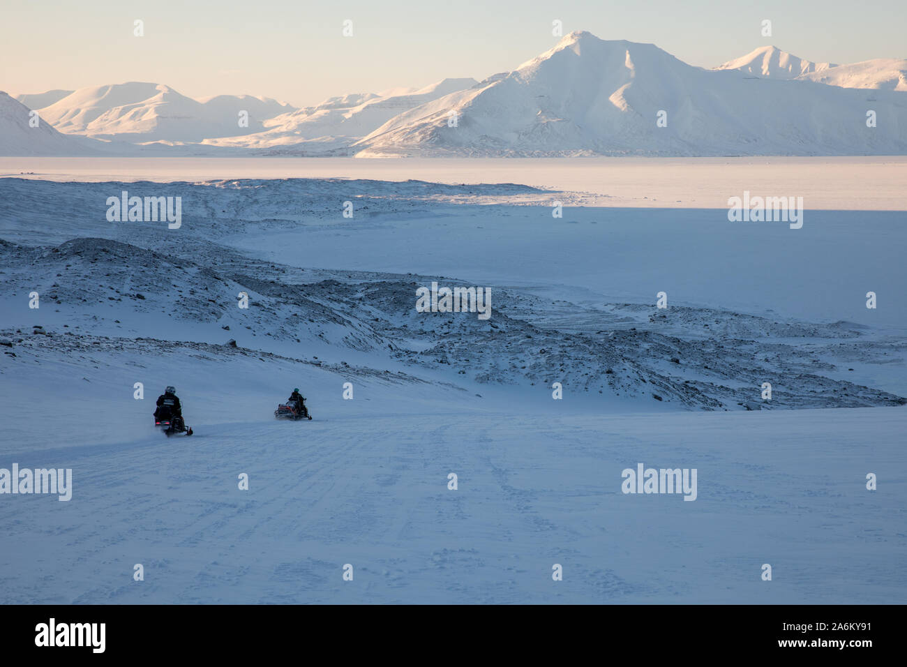 Svalbard, Norway - march 2019: Two snowmobiles driving through the ...