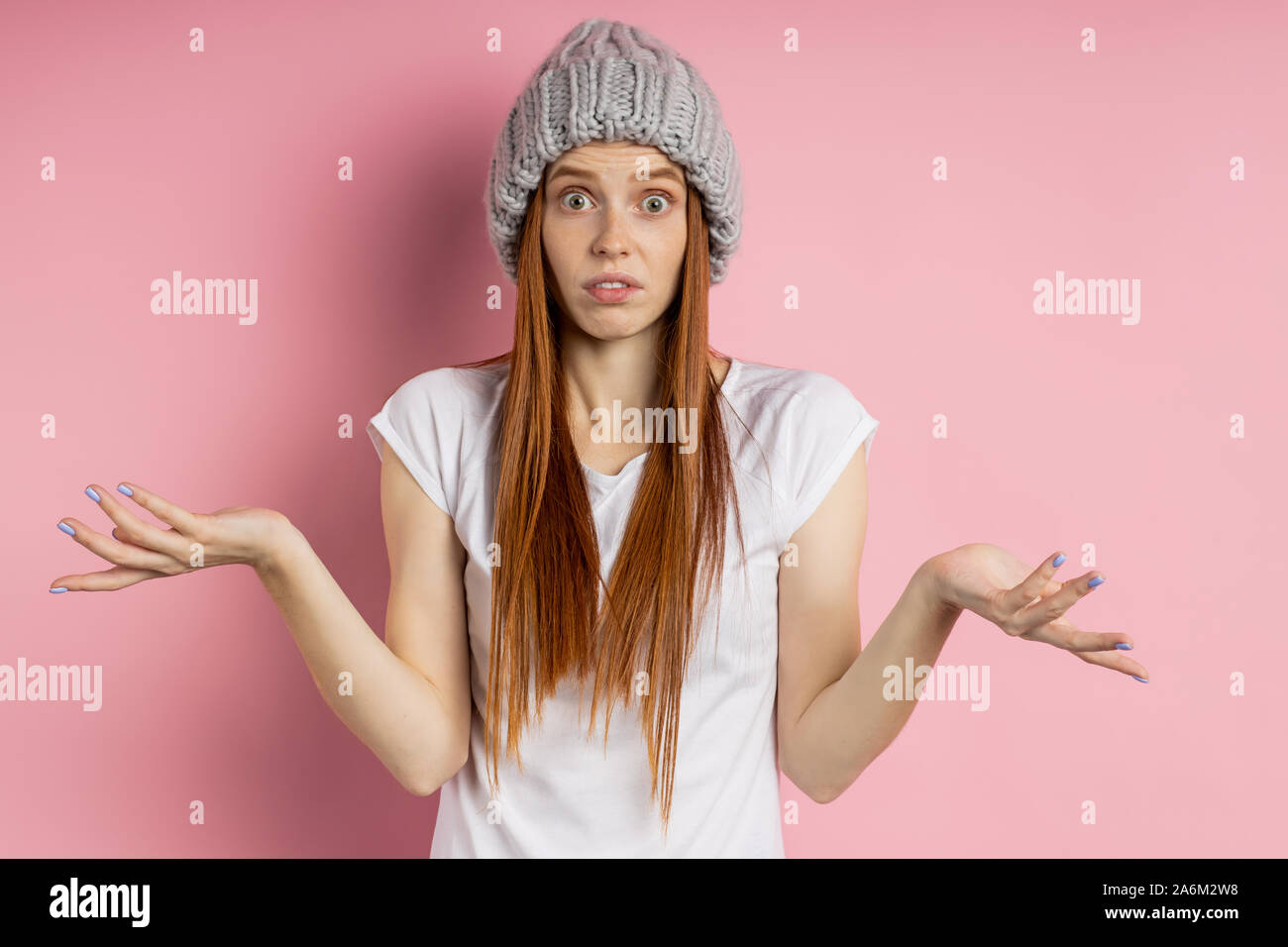 Unsure confused caucasian redhead freckled young woman shrugging her ...