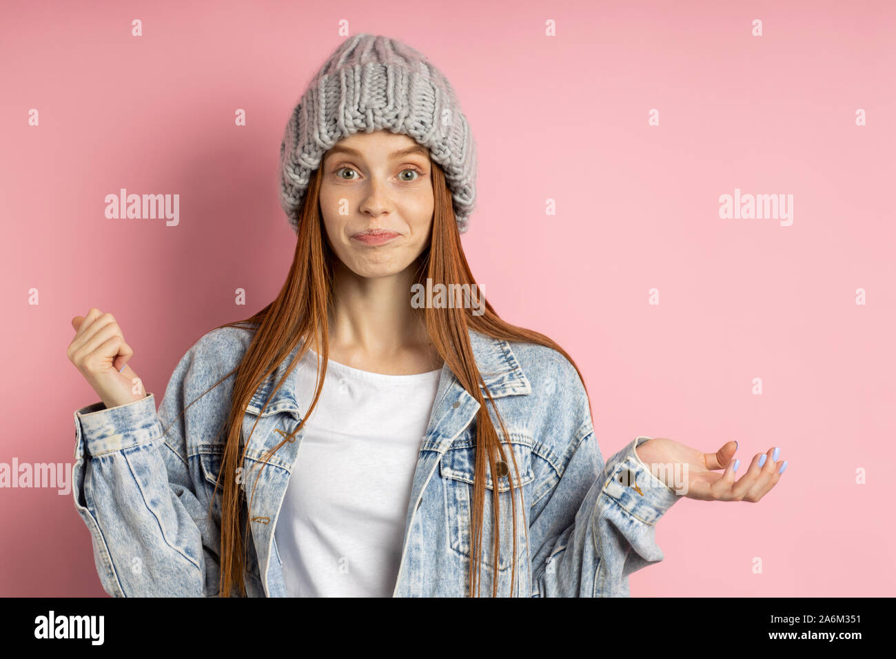 Portrait of bewildered caucasian ginger female wearing denim jacket ...