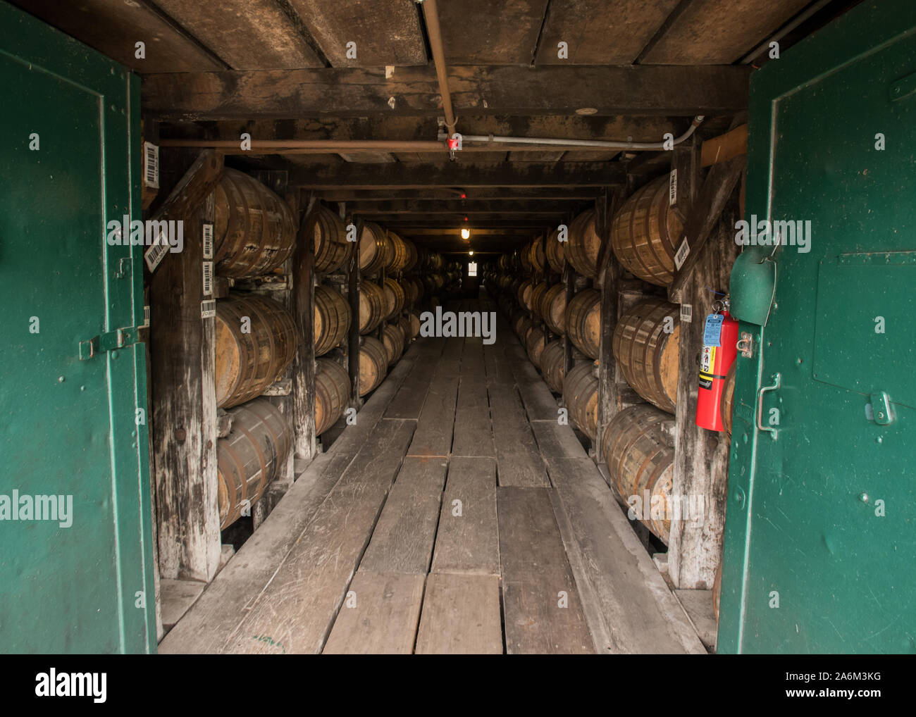 Barrels in Storage Building at Distillery with green doors Stock Photo ...