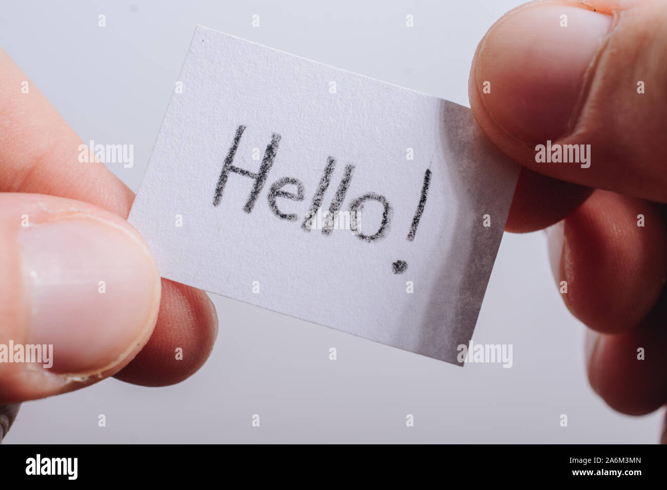 Hand holding notepaper with HELLO wording on white background Stock ...