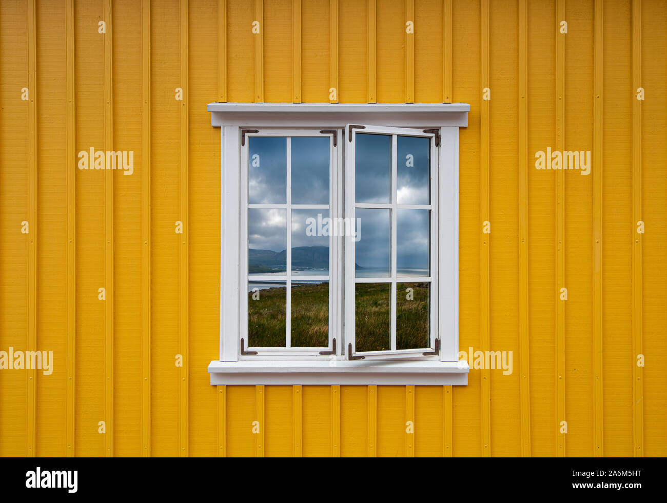 Typical icelandic yellow house with white frame and landscape ...