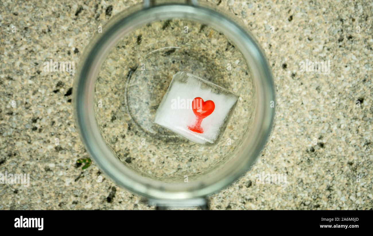 Red elastic rubber heart frozen in an ice cube melting in the sun Stock ...