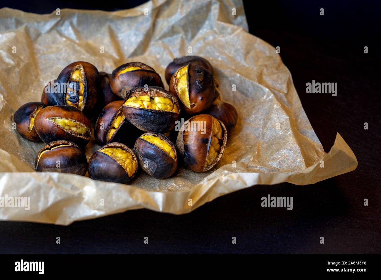 close up roasted chestnuts on paper and black stone background Stock ...