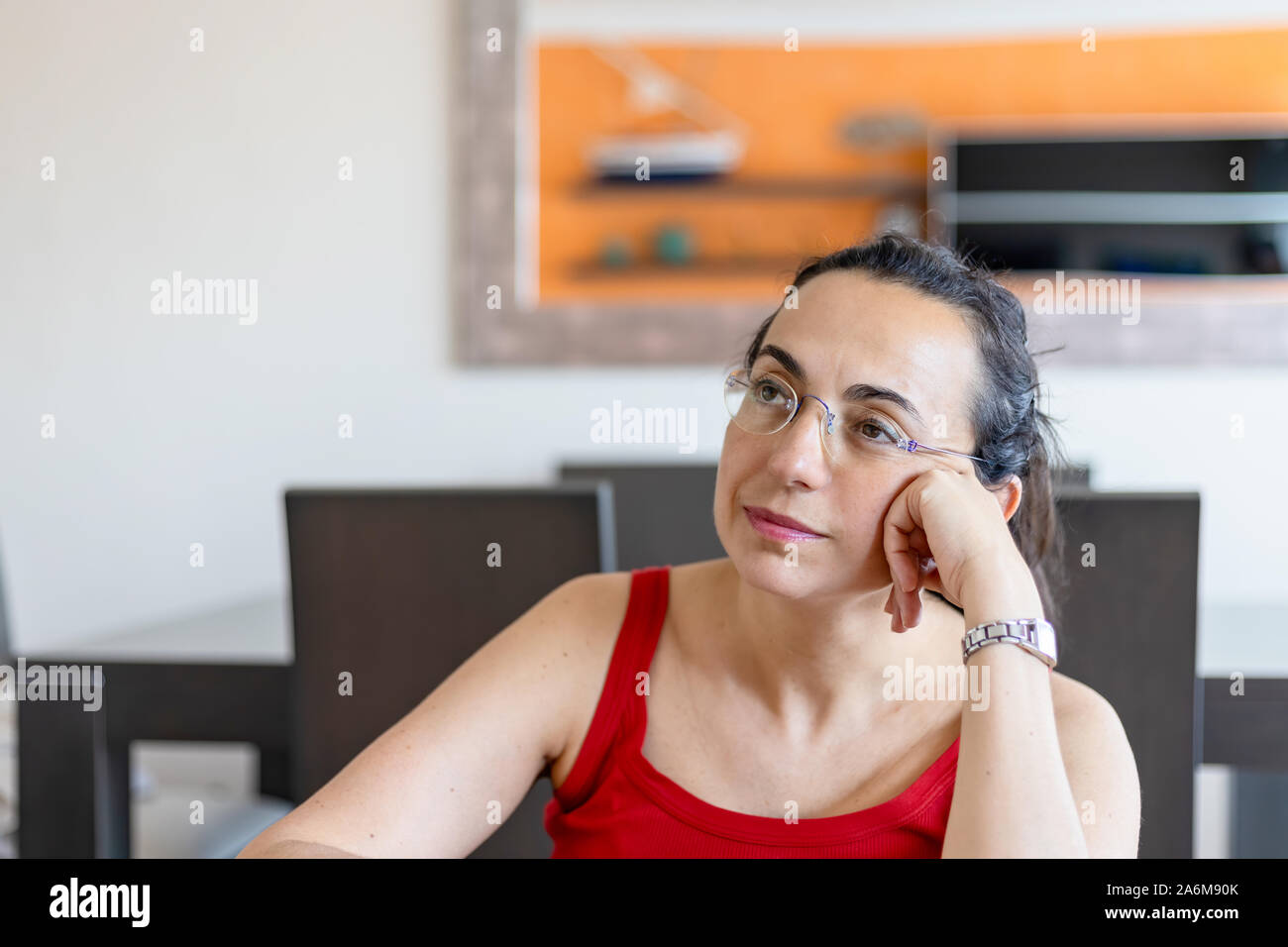 Pretty Spanish woman thinking anything at home Stock Photo - Alamy
