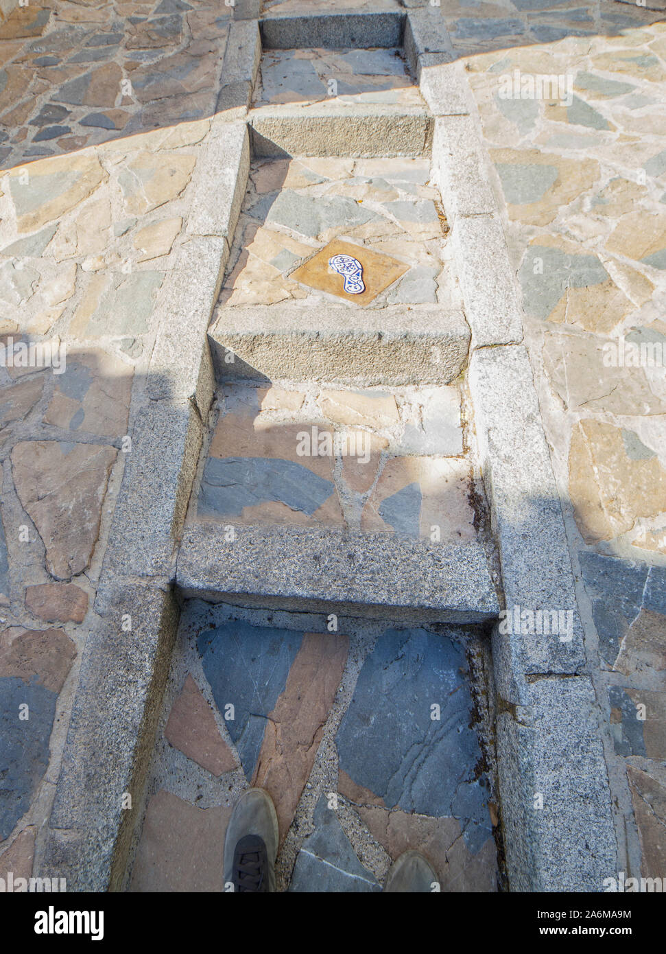 Tourist feet following ceramic tile footprint used to guide visitors ...