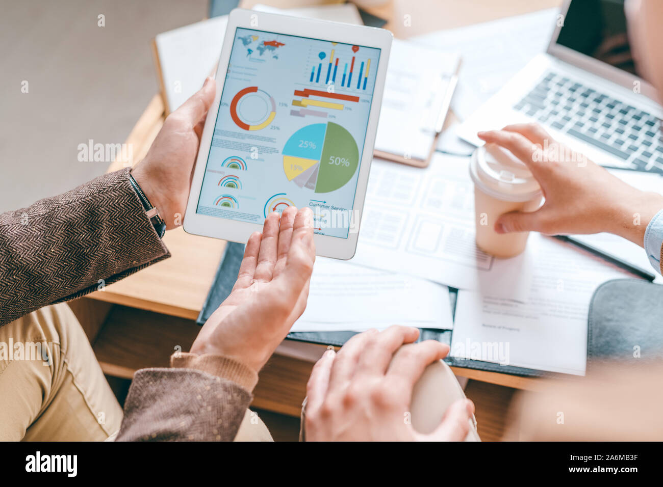 Young male economist with touchpad pointing at financial diagram on ...