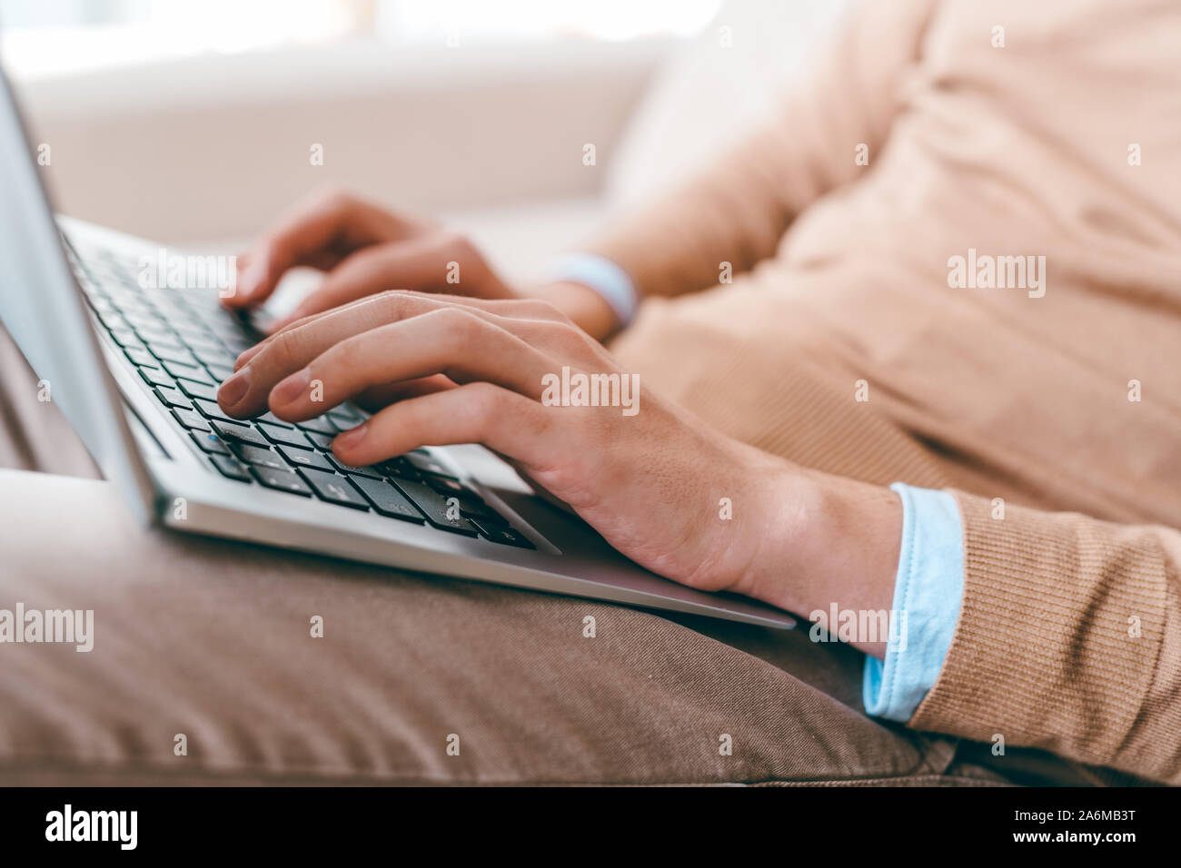 Hands of young casual man touching keys of laptop keypad while ...