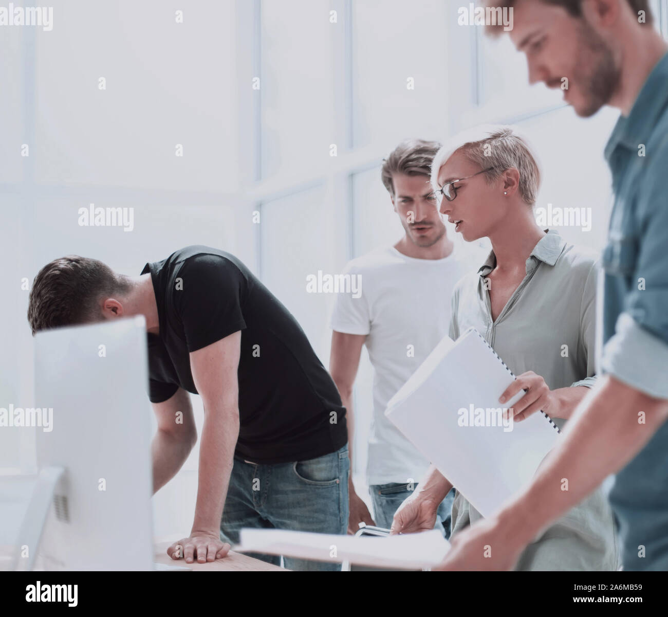 group of designers with sketches standing near the desktop Stock Photo ...