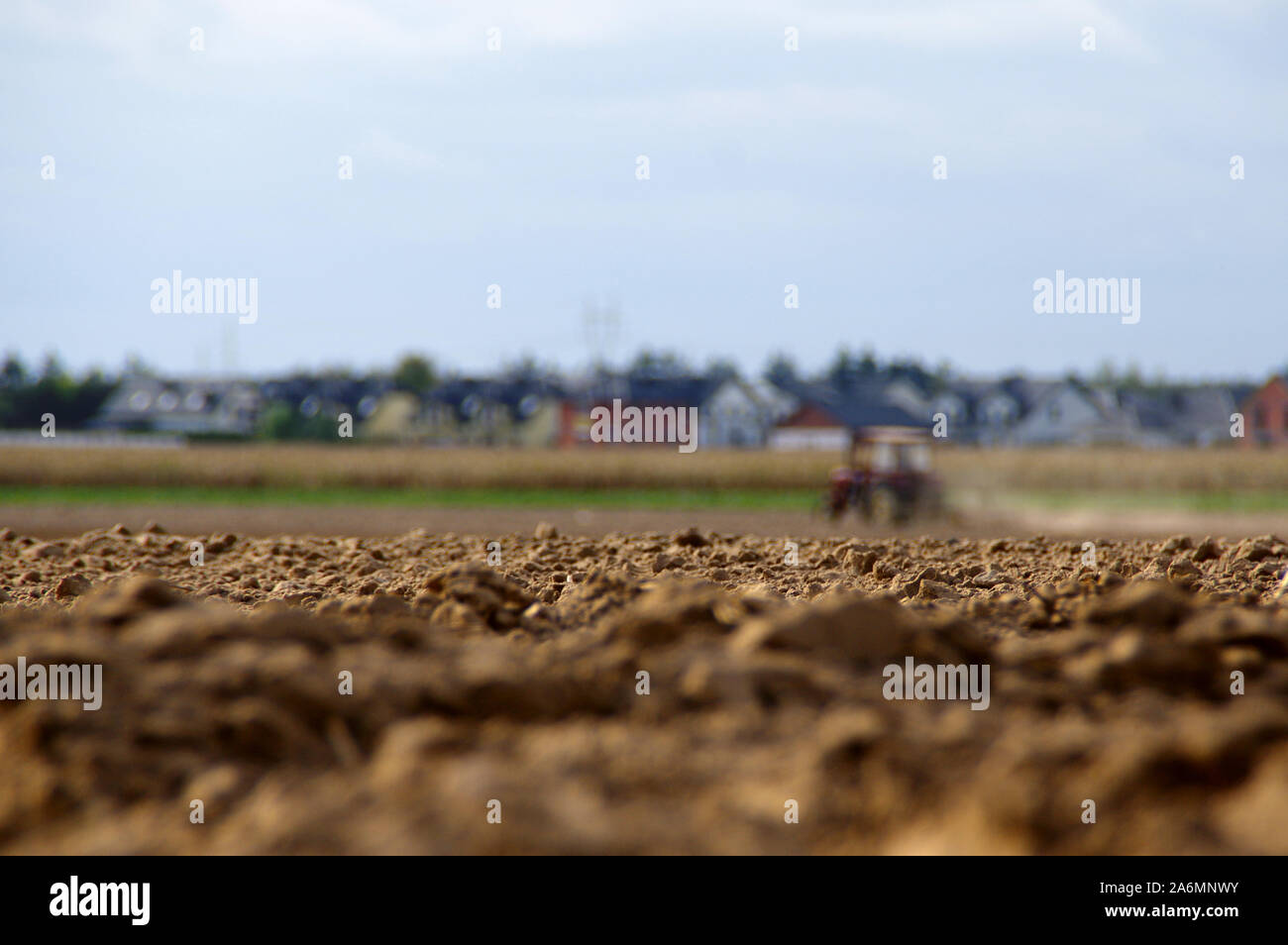 Farmer plowing the dry land with an old tractor in background ...