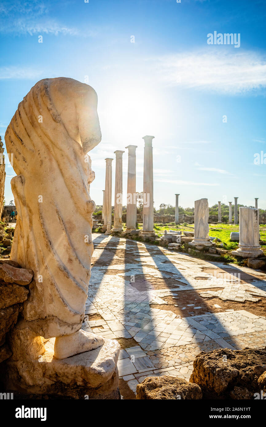Marble statue under the sun rays and ancient columns at Salamis, Greek ...