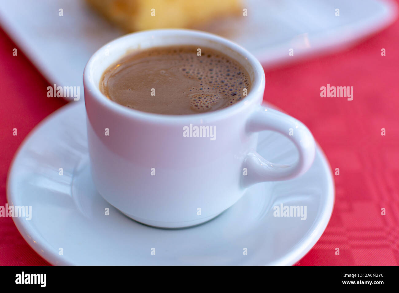 Traditional greek coffee served in white coffee set in cafe close up ...