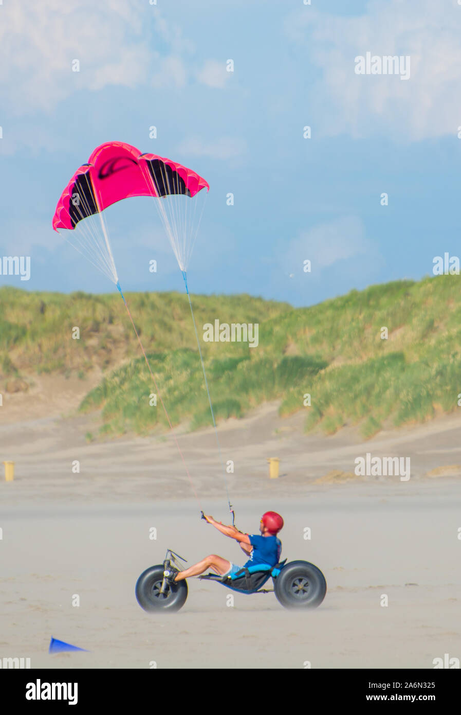 Off-road driving wind buggy on sandy beach with green sandy dunes ...