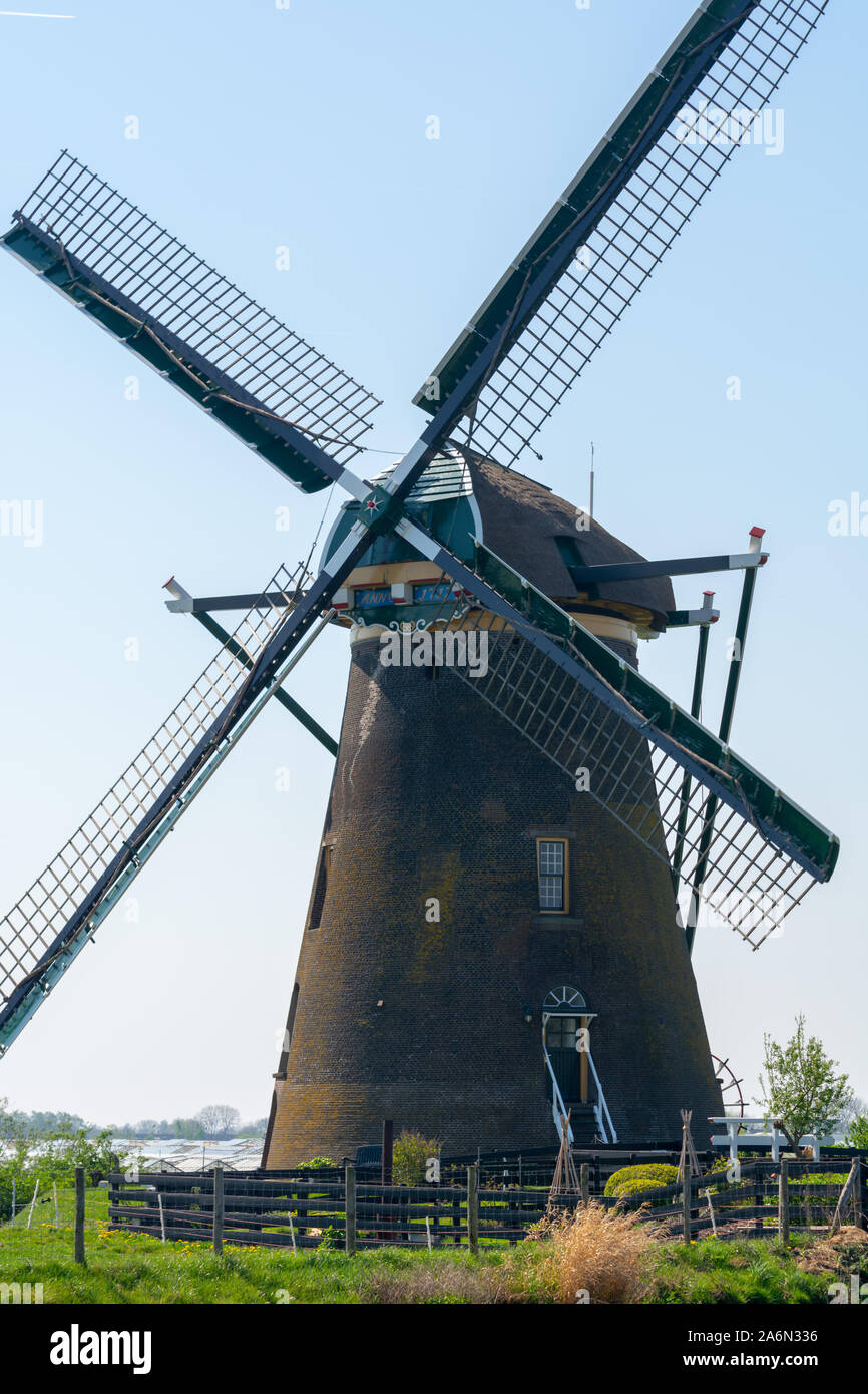 Traditional Dutch wind mill built along canal in North Holland, spring ...