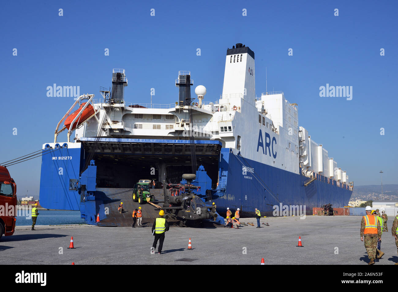 U.S. Army AH-64 Apache helicopter is offloaded from the cargo vessel ...