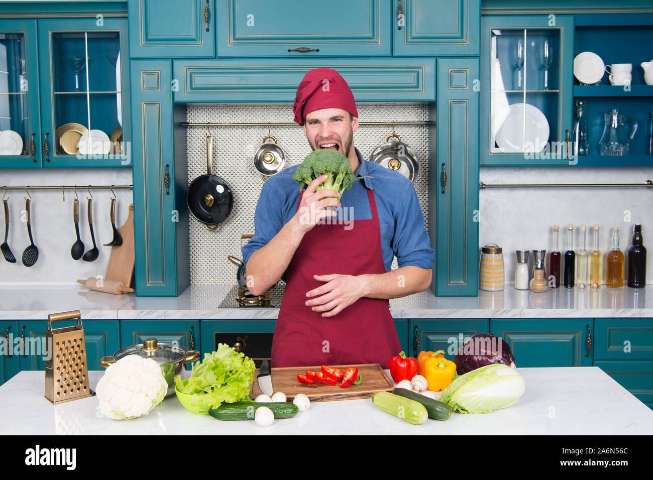 Go green. Handsome cook in kitchen. Chef following recipe. Cooking ...