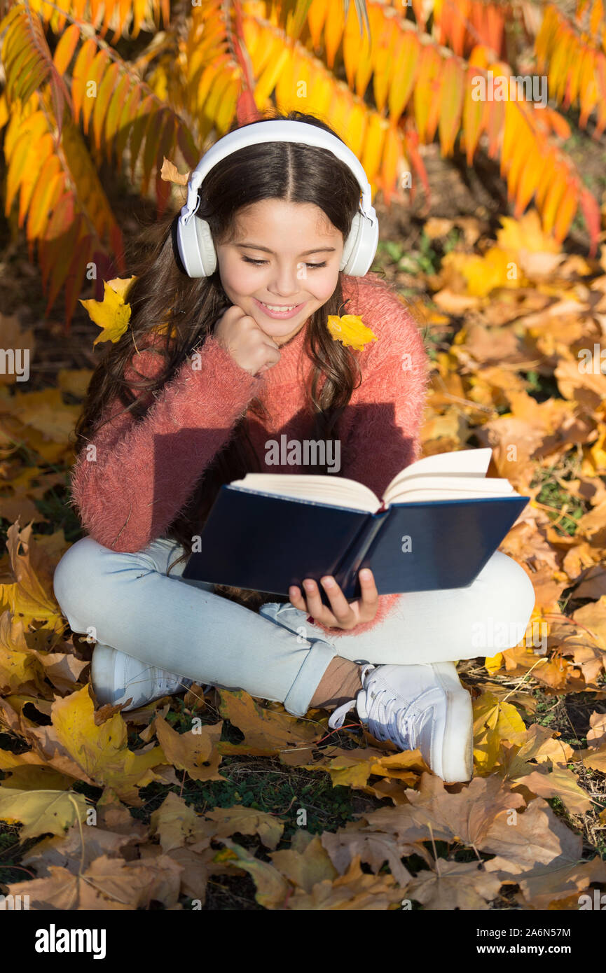 Girl read book autumn day. Little child enjoy learning at backyard. Kid ...