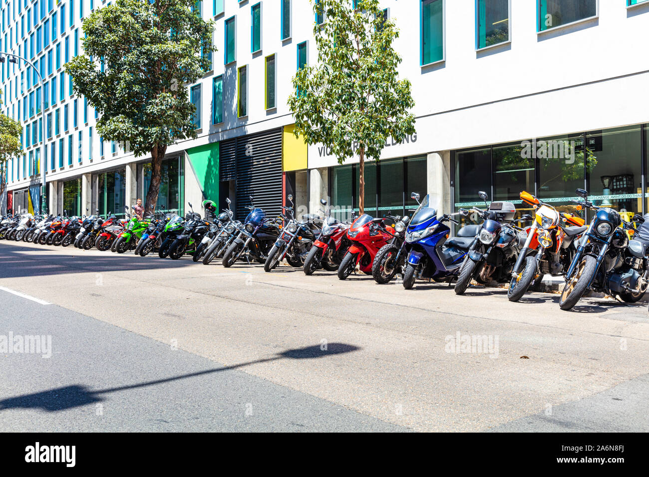 A long line of parked motorcycles in an urban setting Stock Photo - Alamy