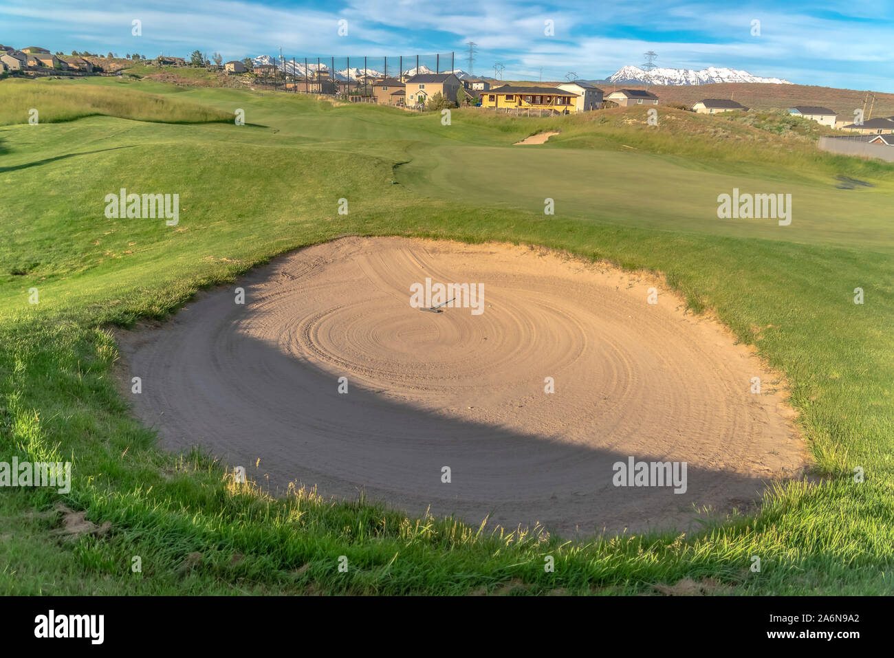 Close up view of a sand trap at a sunny golf course with houses in the ...