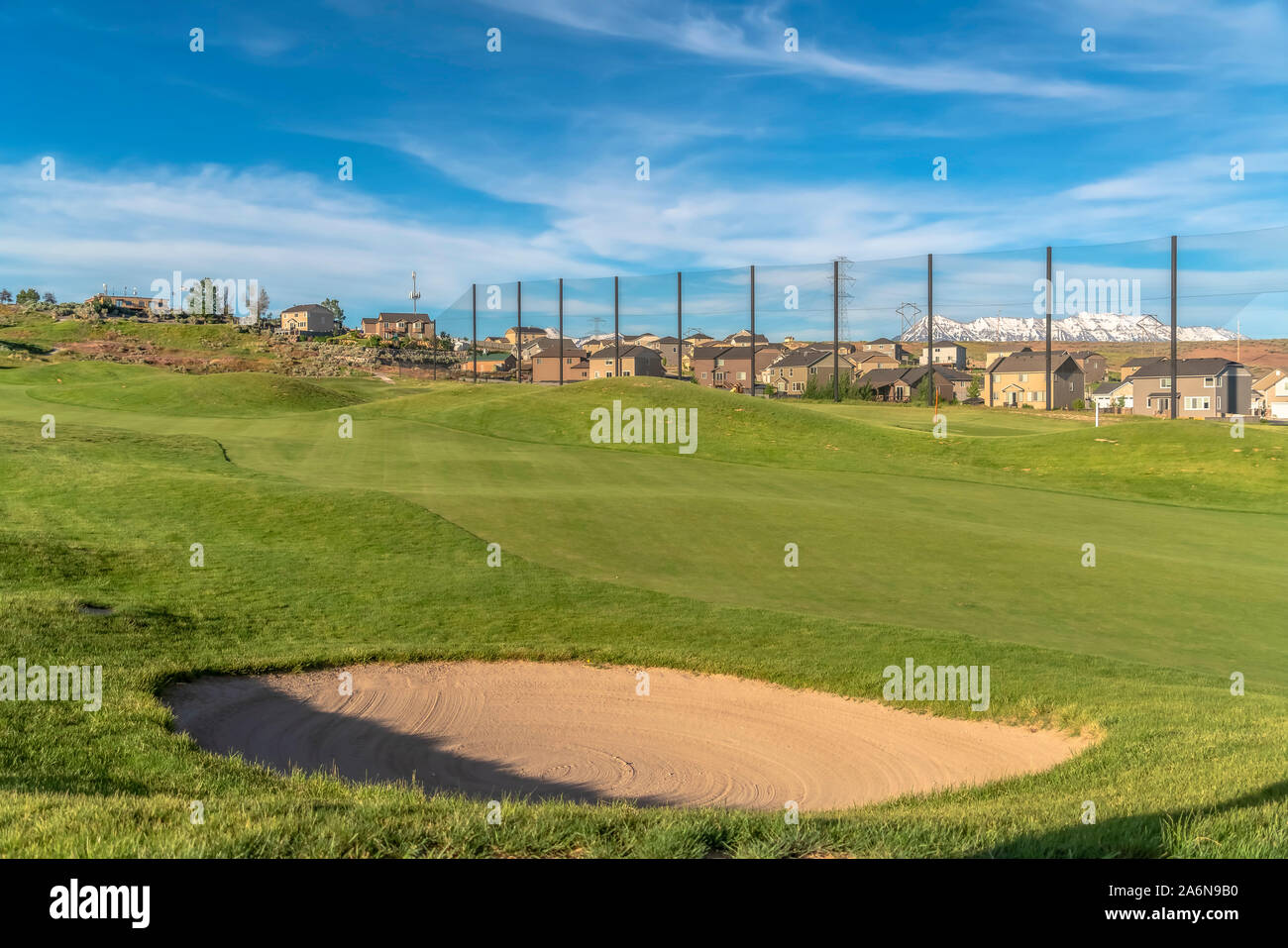 Focus on a sand trap surrounded by short green grasses at a sunny golf ...