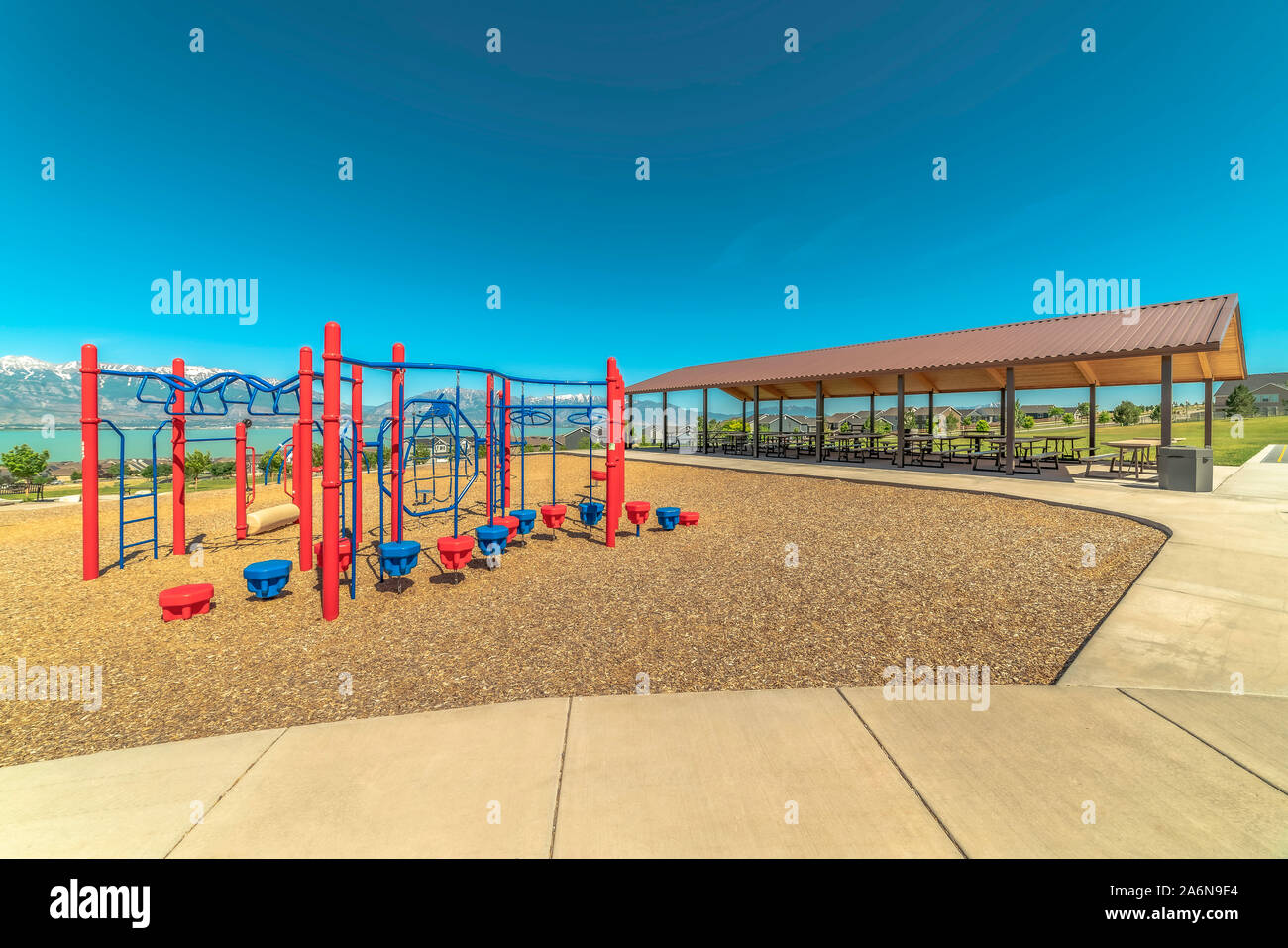 Climbing bars and steps playground equipment at a park against lake and ...