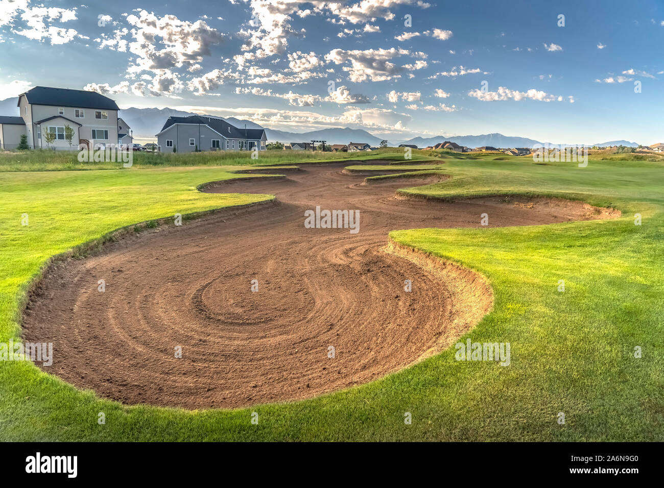 Sand trap and fairway of a golf course with lake front houses in the ...
