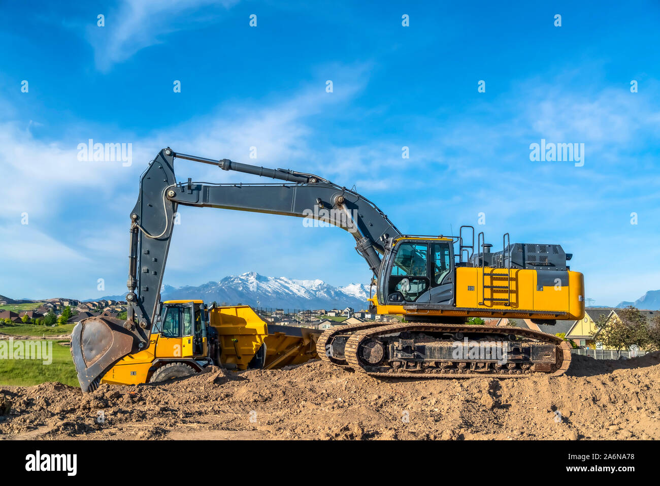Excavator with metal arm and bucket and continuous tracks at a ...