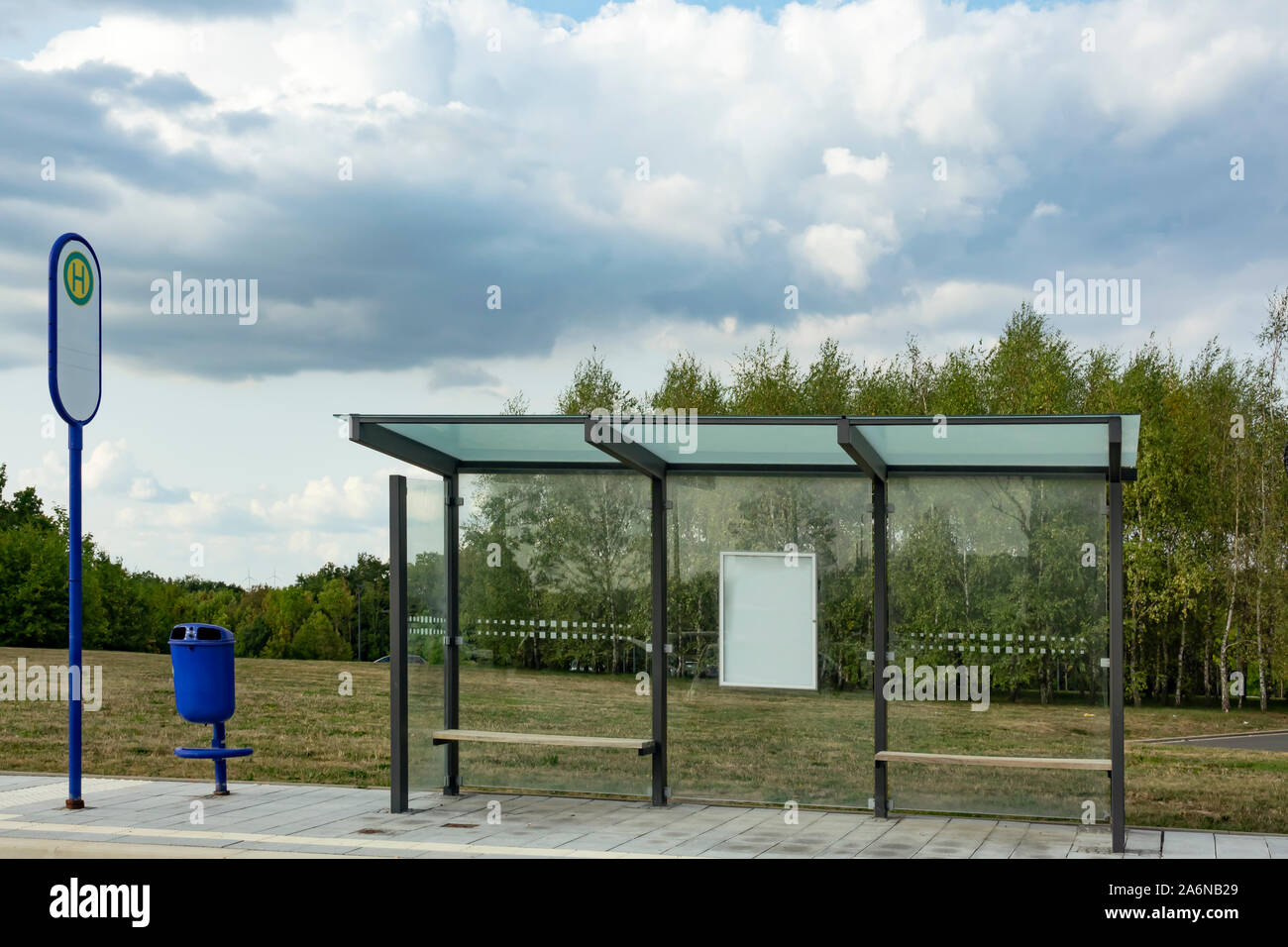 Modern Bus Stop with trash can with cloudy Sky Stock Photo - Alamy