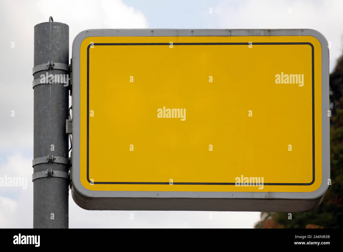 Yellow blank sign hanging on a metal post Stock Photo - Alamy