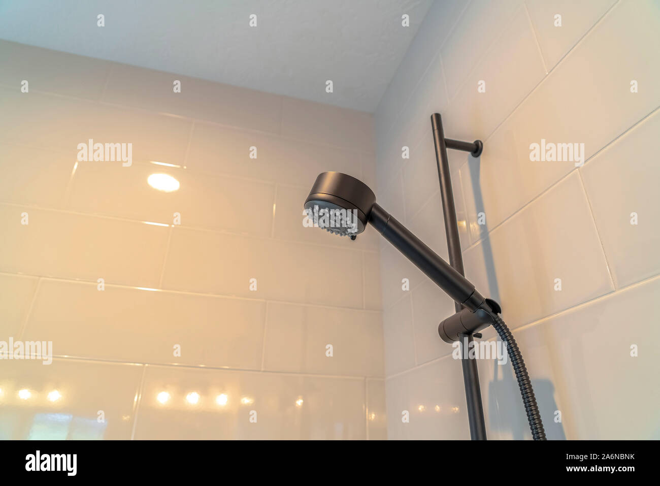 Shower head in a white tiled shower cubicle Stock Photo - Alamy
