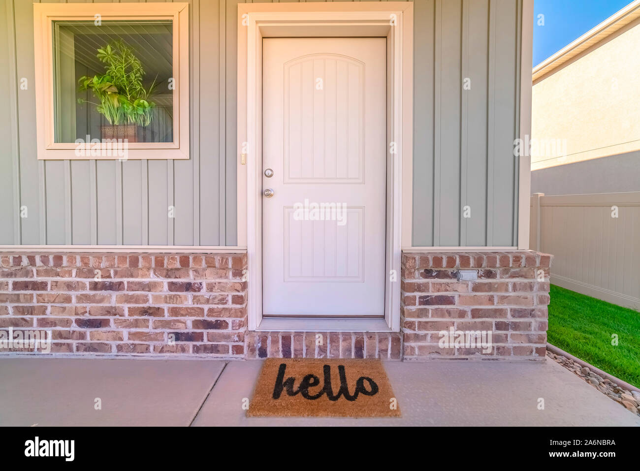 Front door and porch of home with hello mat Stock Photo - Alamy