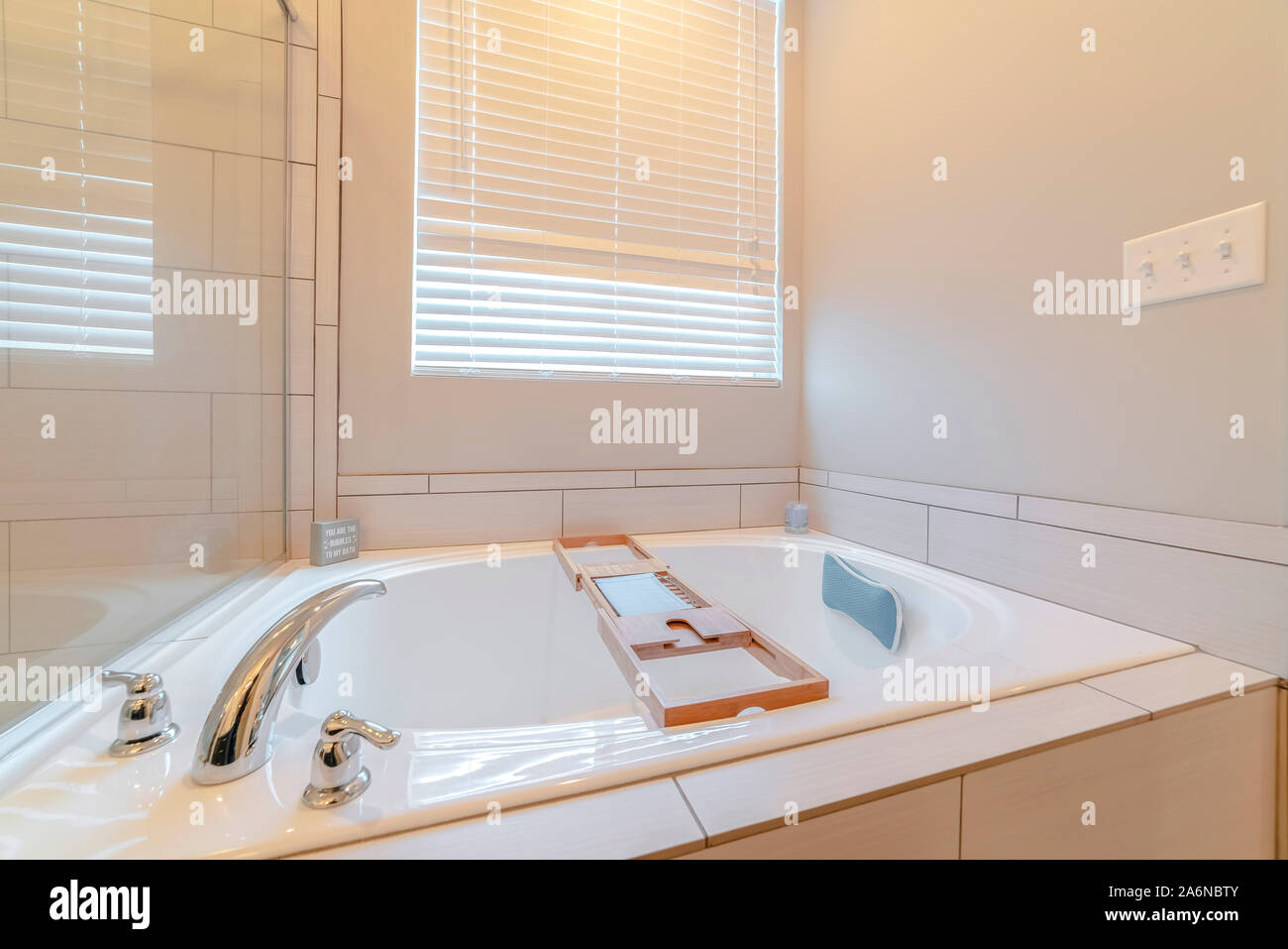 Contemporary spa bath with wooden tray caddy Stock Photo - Alamy