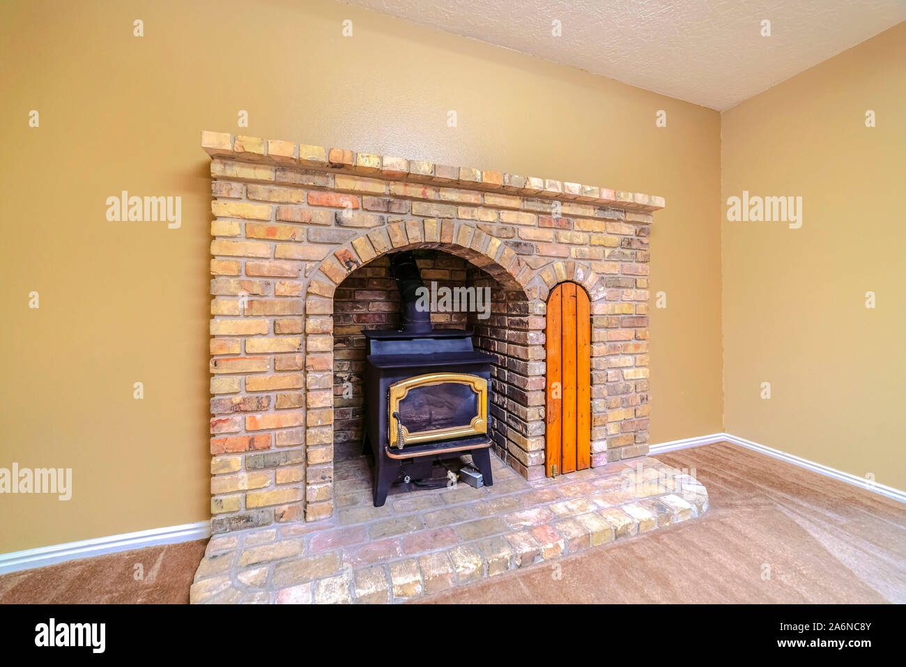 Brick fireplace with insert furnace indoor room Stock Photo - Alamy