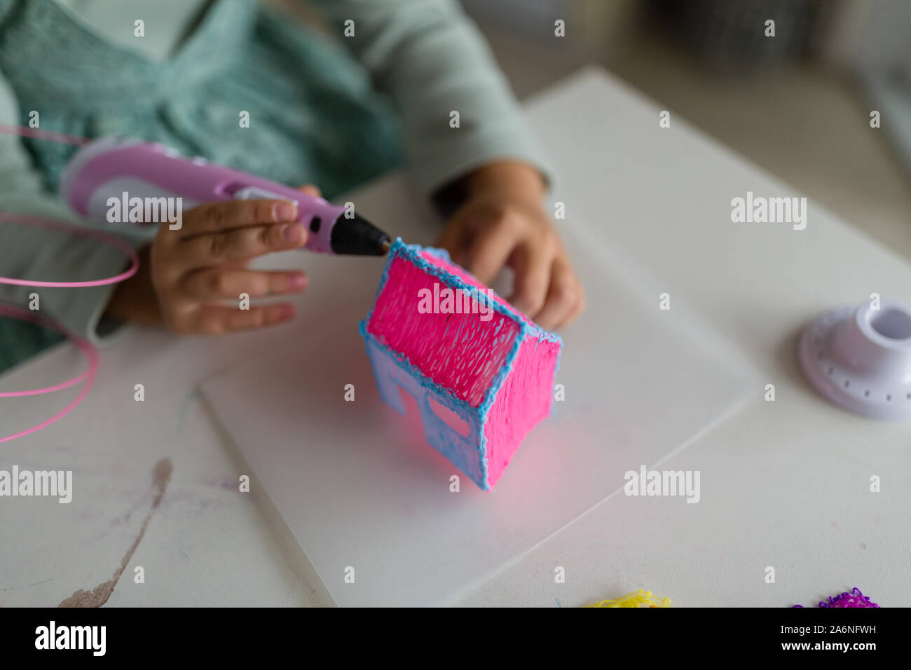 Cute little girl makes a plastic house, draws parts with a 3D pen. STEM ...