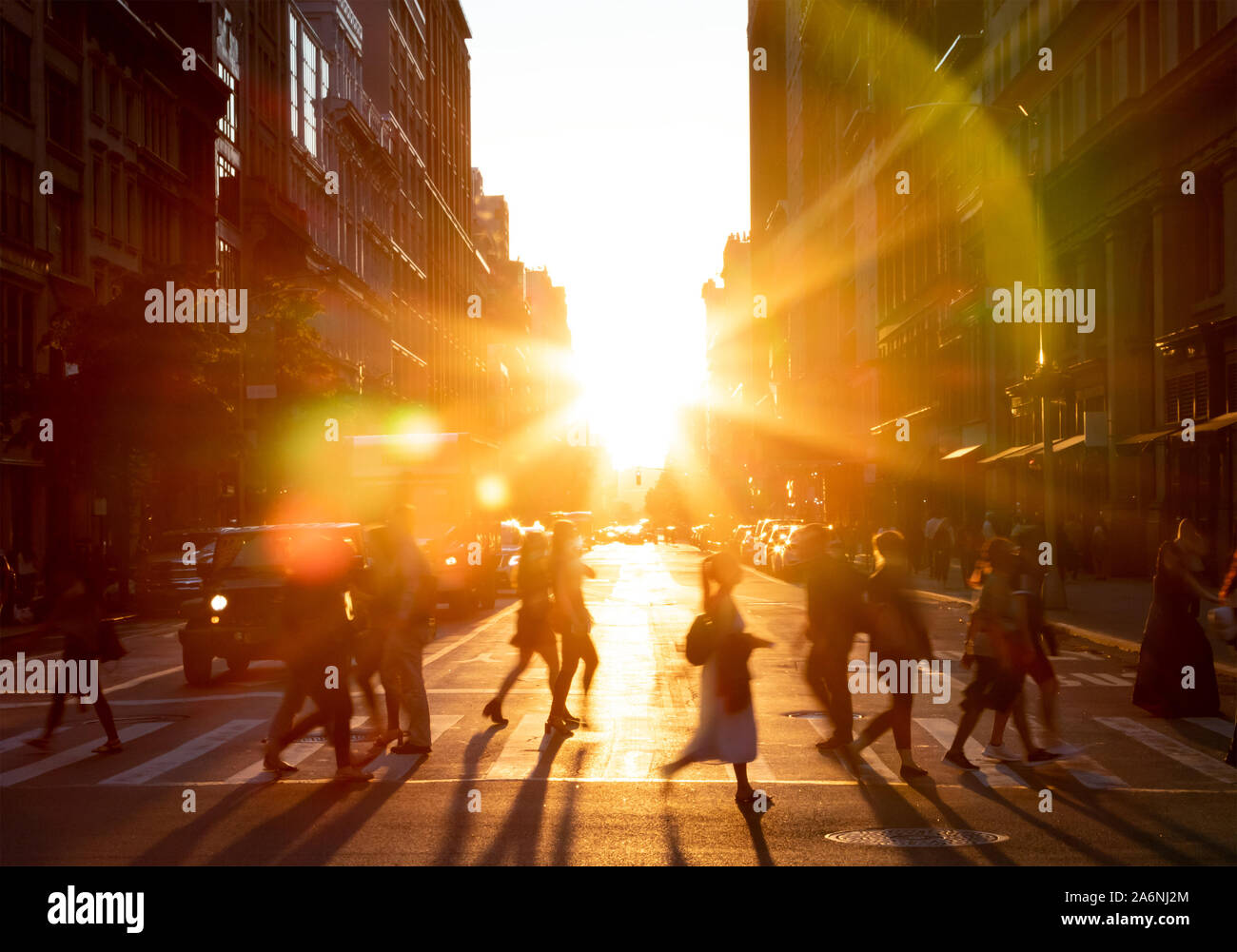 People walking across the street in New York City with the bright light ...
