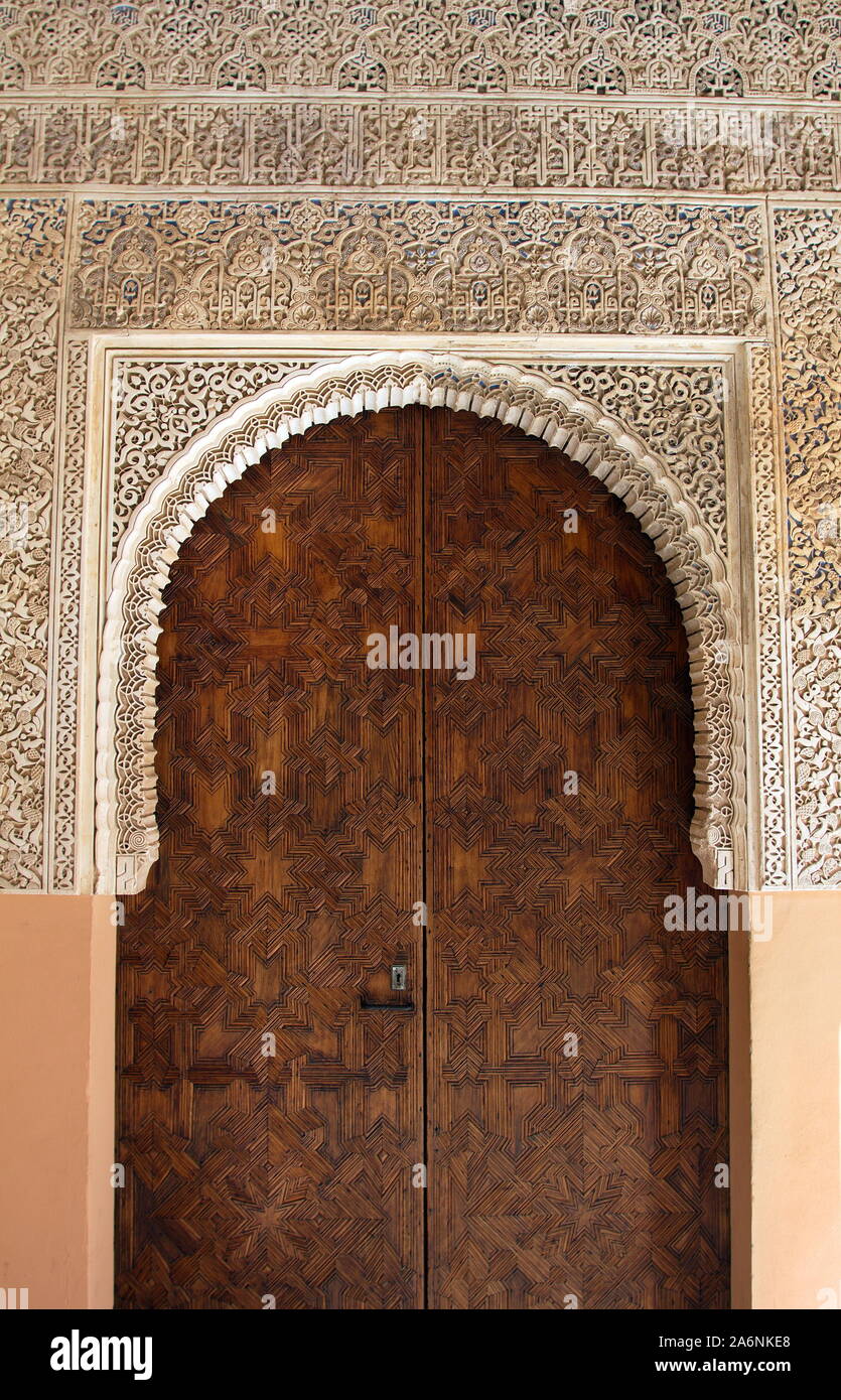 Stucco carving in Arabic script around a doorway in the Alhambra palace ...