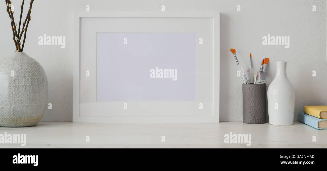 Minimal artist studio with mock up frame and office supplies on white ...
