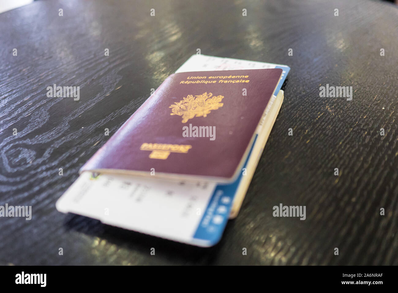 partially burred French passport on table with plane boarding pass ...