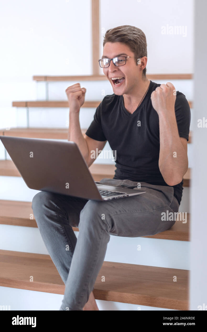 happy young man looking at his laptop screen Stock Photo - Alamy