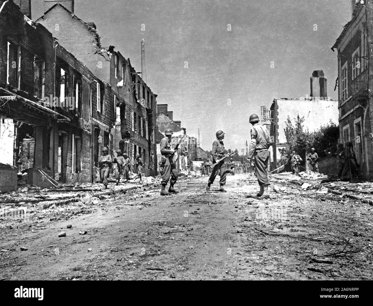 Still a bit leery of German snipers and mortar fire, these infantrymen ...