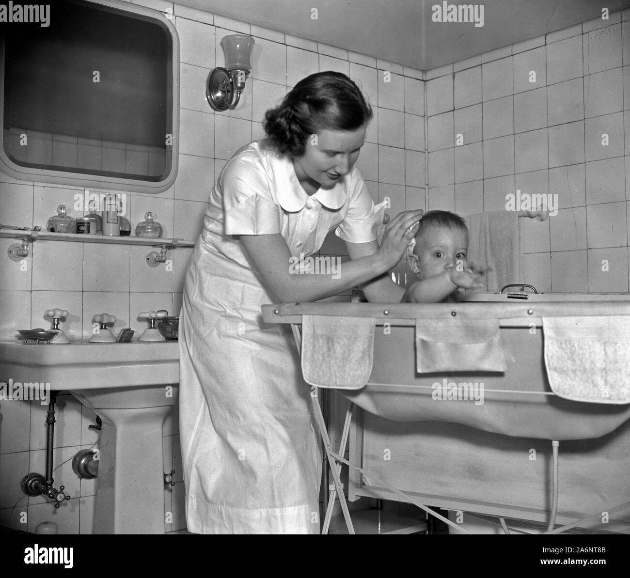 A woman giving a baby its bath ca. 1937 Stock Photo - Alamy