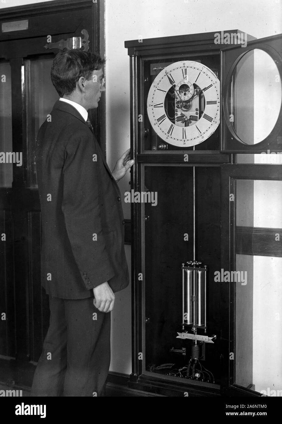 Chester Burleigh Watts turning back the hands of a clock at the Naval ...