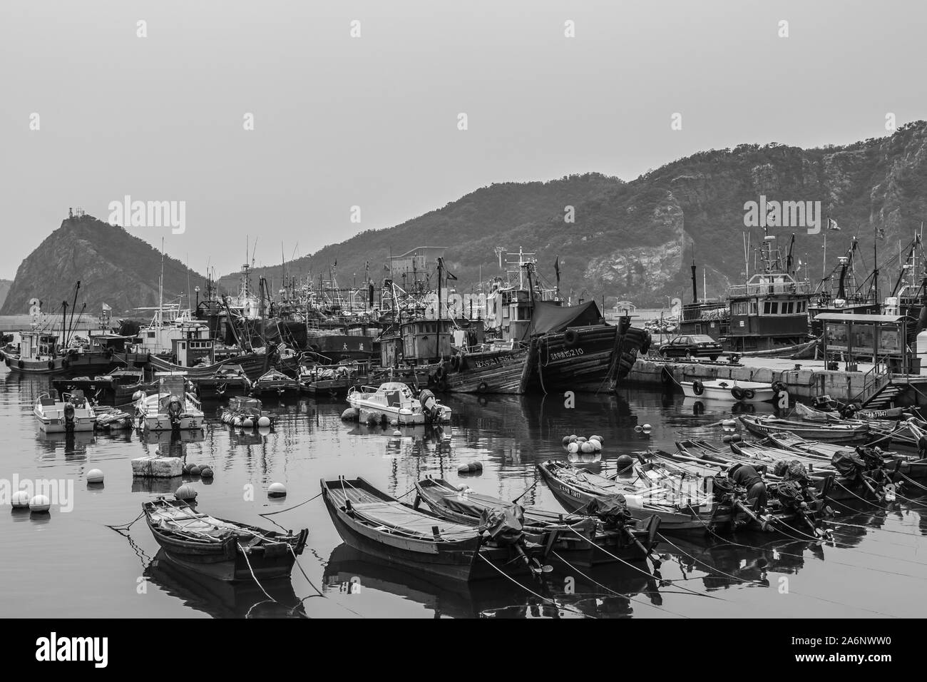 Black and white picture of big and small boats in Dalian old harbor, in ...